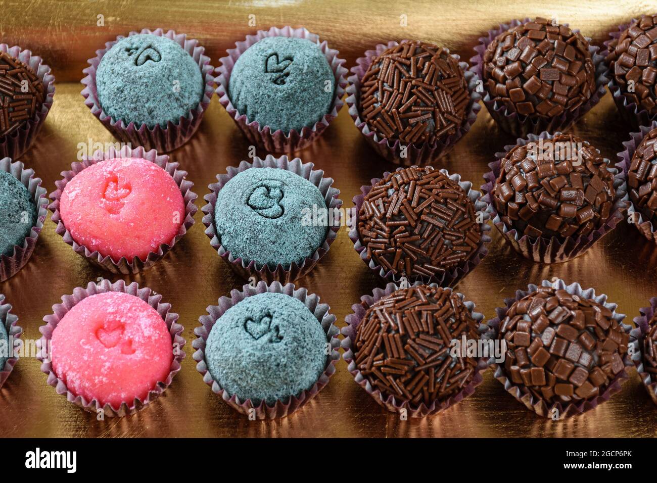 Closeup of various types of brigadeiro on a golden tray. Brazilian ...