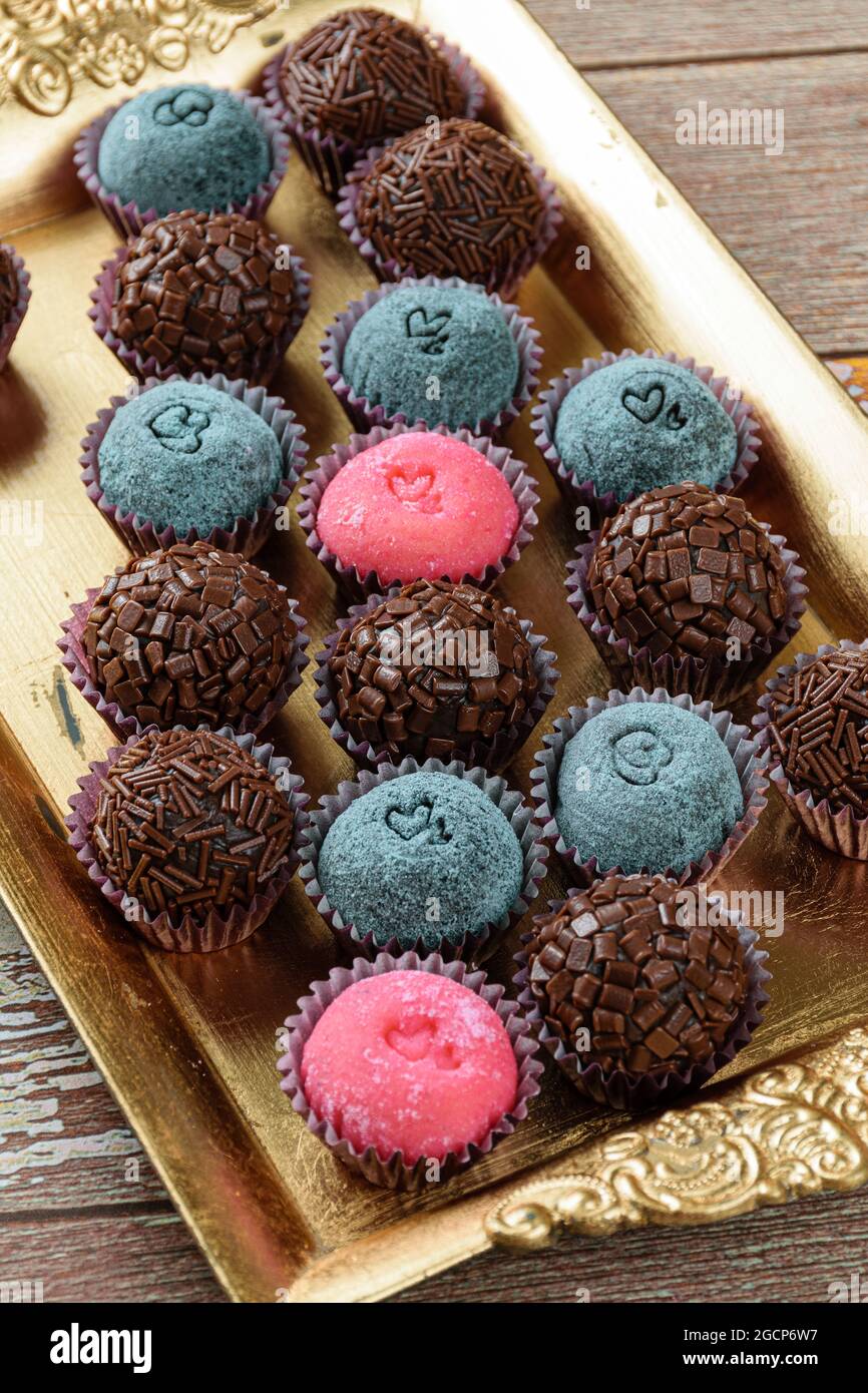 Various types of brigadeiro lined up on a golden tray. Brazilian ...