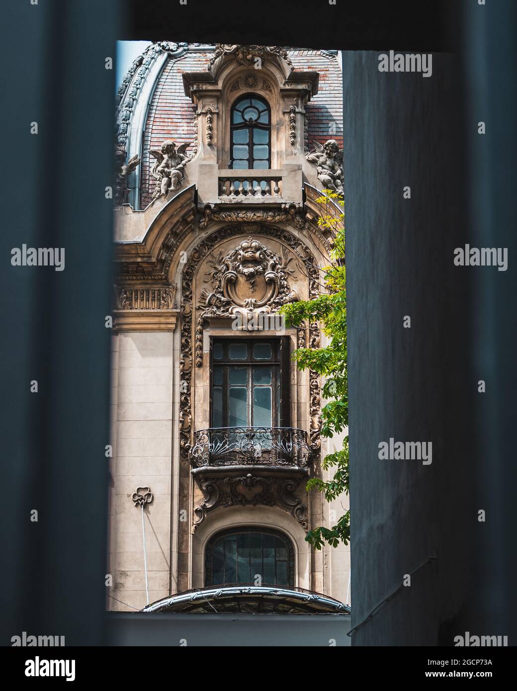 Building's terraces view through a concrete wall alley Stock Photo - Alamy