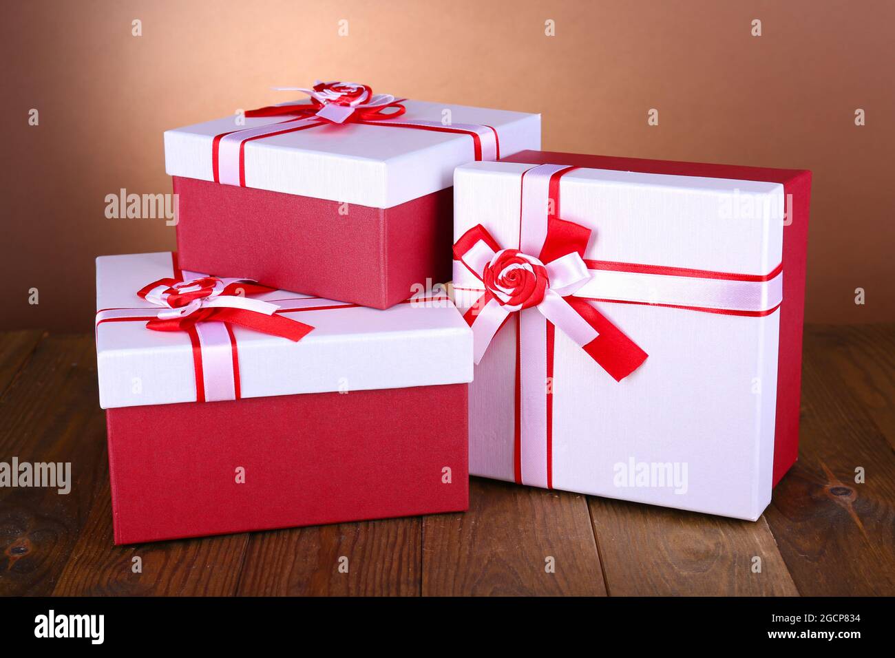Beautiful gift boxes on table on brown background Stock Photo - Alamy