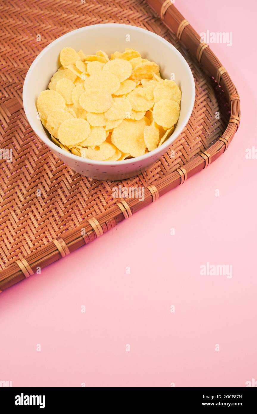 Bowl of cornflakes on a wooden tray isolated on pink surface with free ...