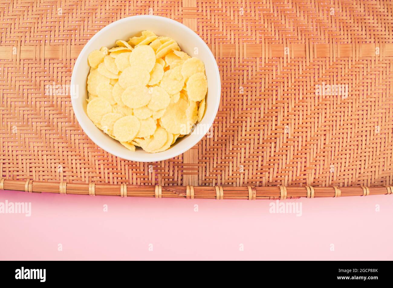 Bowl of cornflakes on a wooden tray isolated on pink surface with free ...
