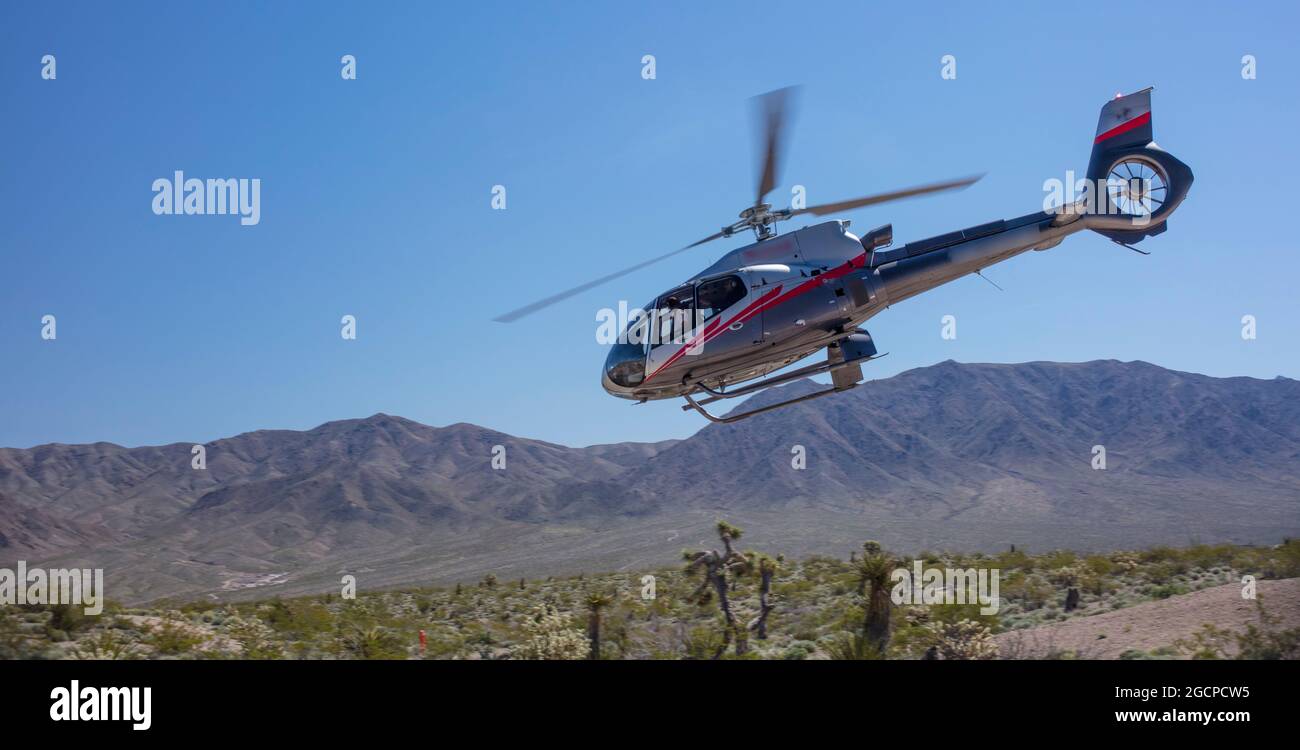 Helicopter flying over desert landscape Stock Photo - Alamy