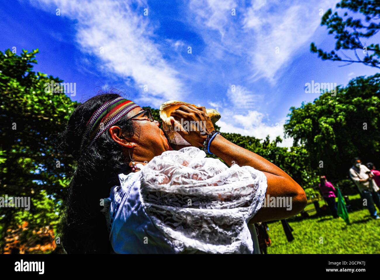 A woman plays a conch during the ceremony. Members of the Izalco Nahua ...