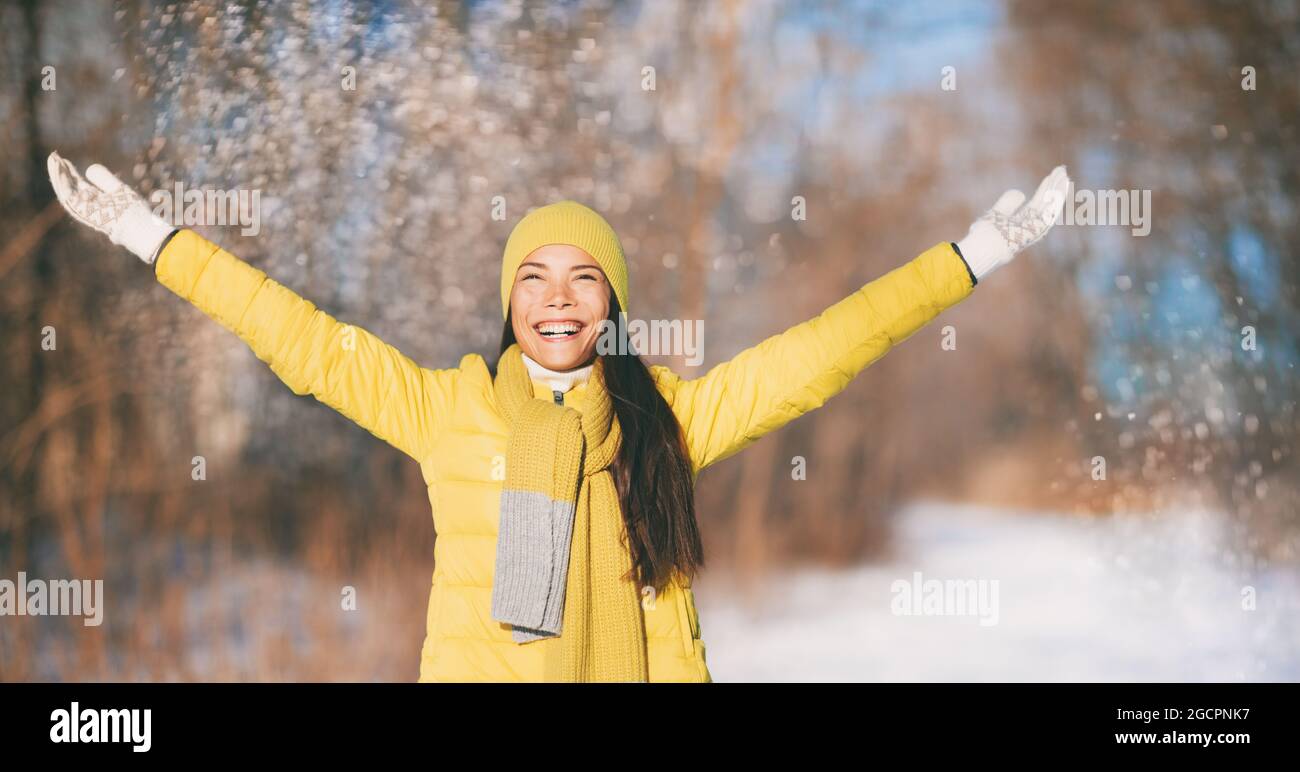 Happy winter snow fun Asian woman playing outside in snowy sunshine ...