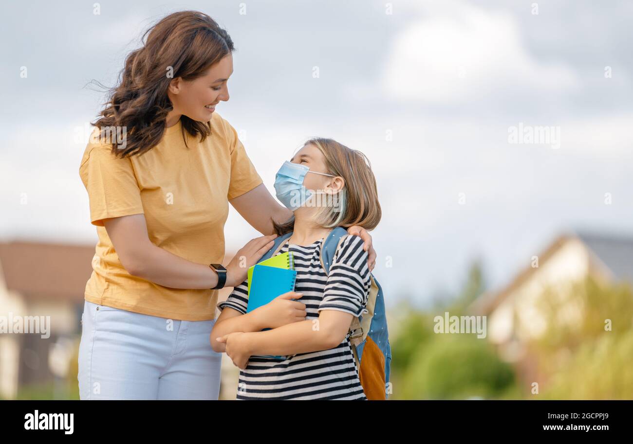 Parent and pupil of secondary school going hand in hand. Woman and girl ...