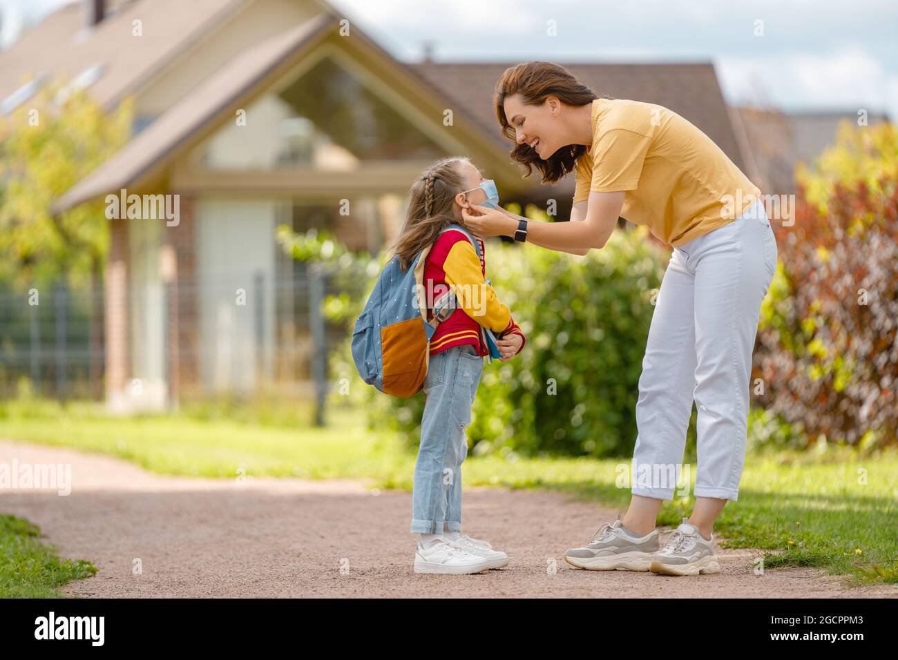 Parent and pupil of secondary school going hand in hand. Woman and girl ...