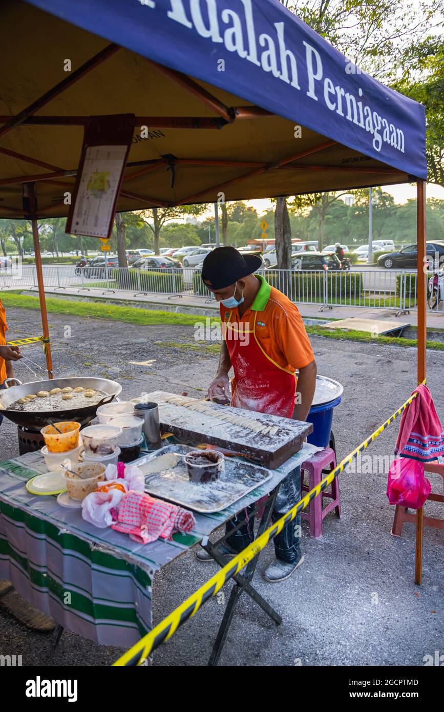 young men frying Youtiao or Cakoi, a long golden-brown deep-fried strip ...