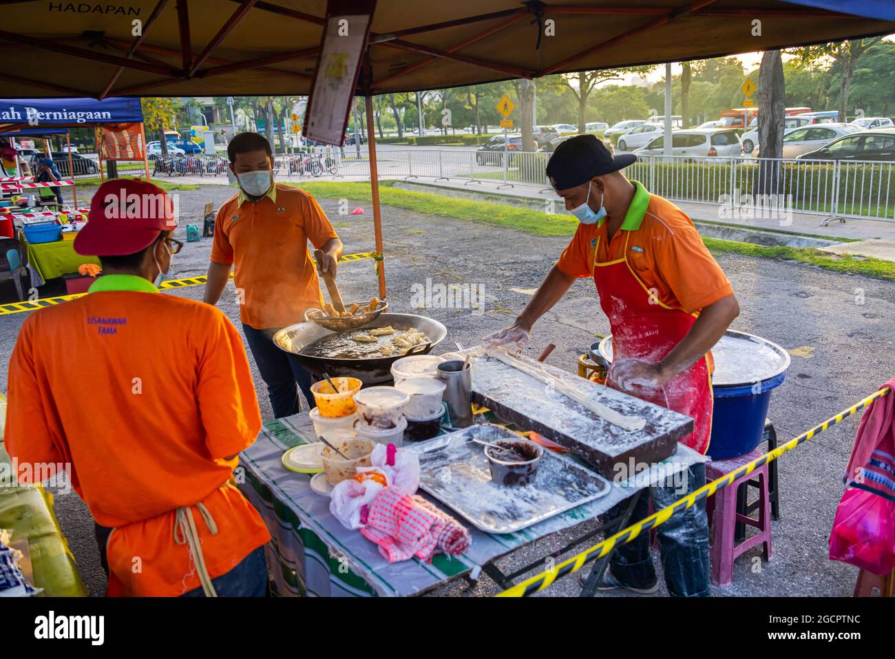 young men frying Youtiao or Cakoi, a long golden-brown deep-fried strip ...