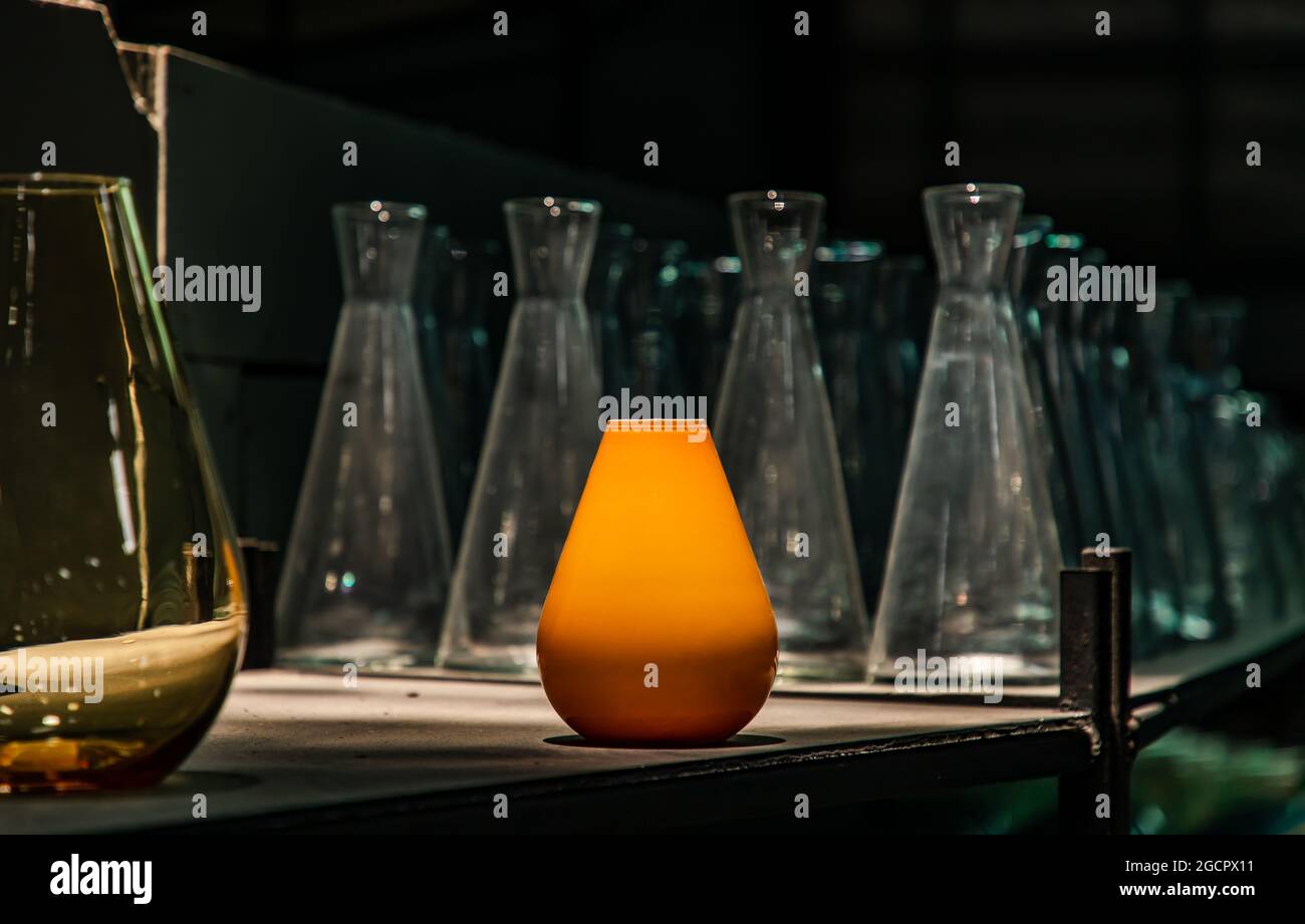A display of yellow glass vases on the shelf at Glassware warehouse ...