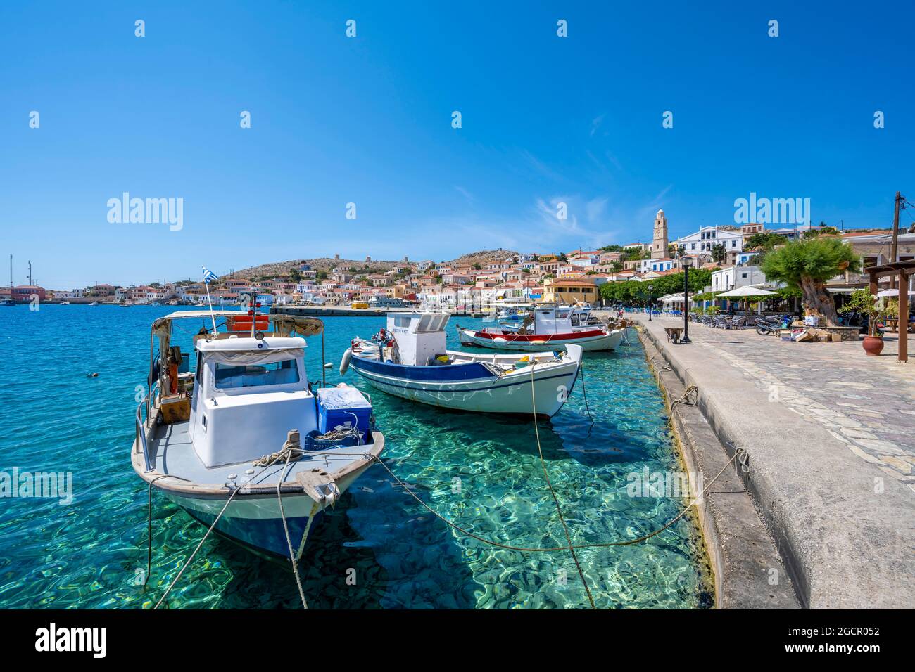 Fishing boats in the harbour of Halki with turquoise blue water ...