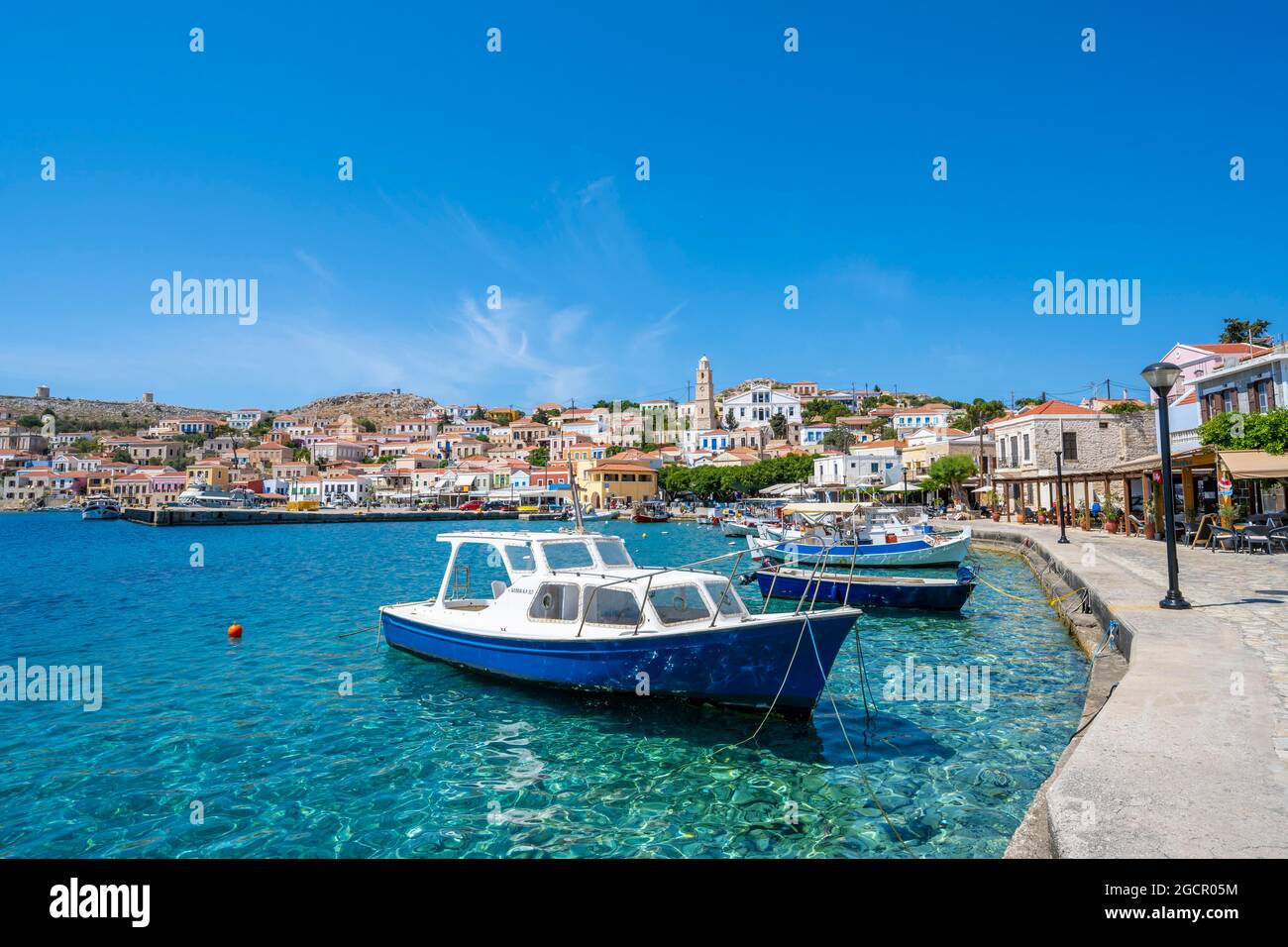 Fishing boats in the harbour of Halki with turquoise water, waterfront ...
