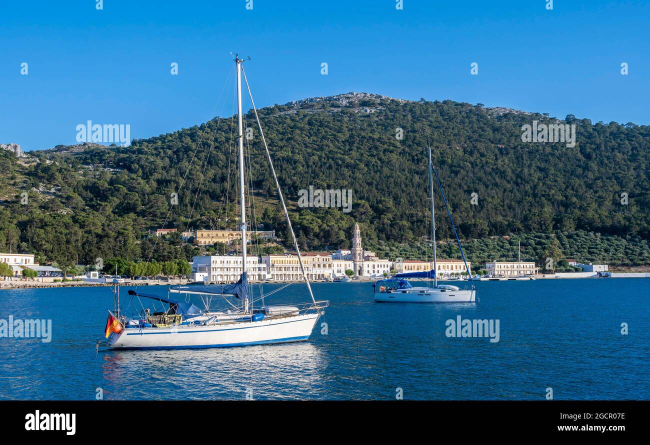 Two sailboats in the bay of Panormitis, behind Monastery of Archangel ...