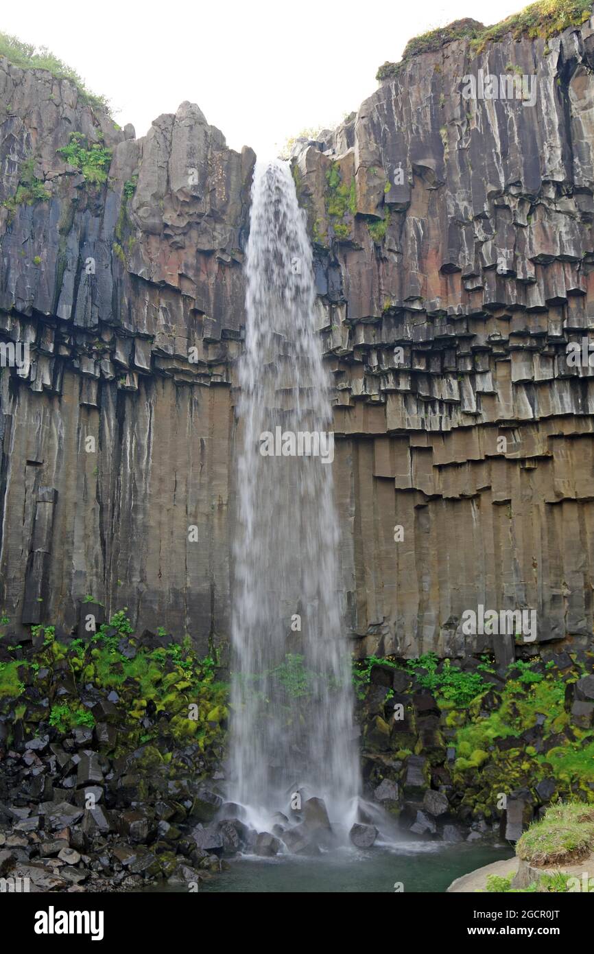 Water masses falling over basalt rock into a basin, Skaftafell National ...