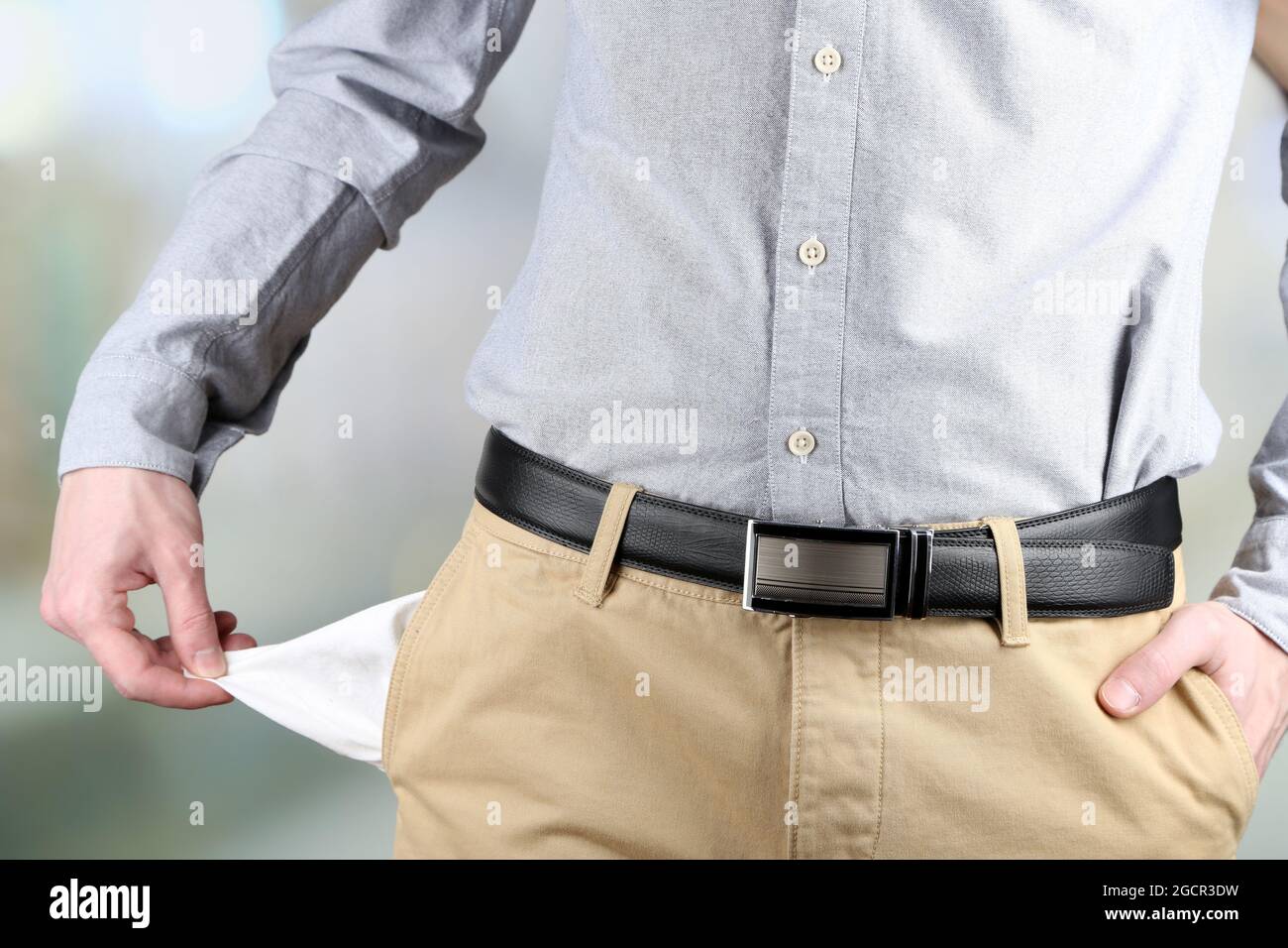 Man showing his empty pocket on bright background Stock Photo - Alamy
