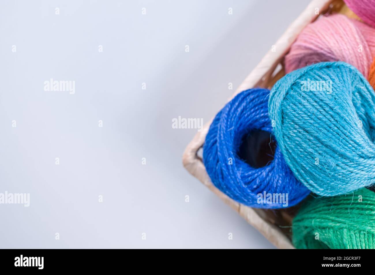 Basket full of colorful yarn rolls isolated on a white background with ...