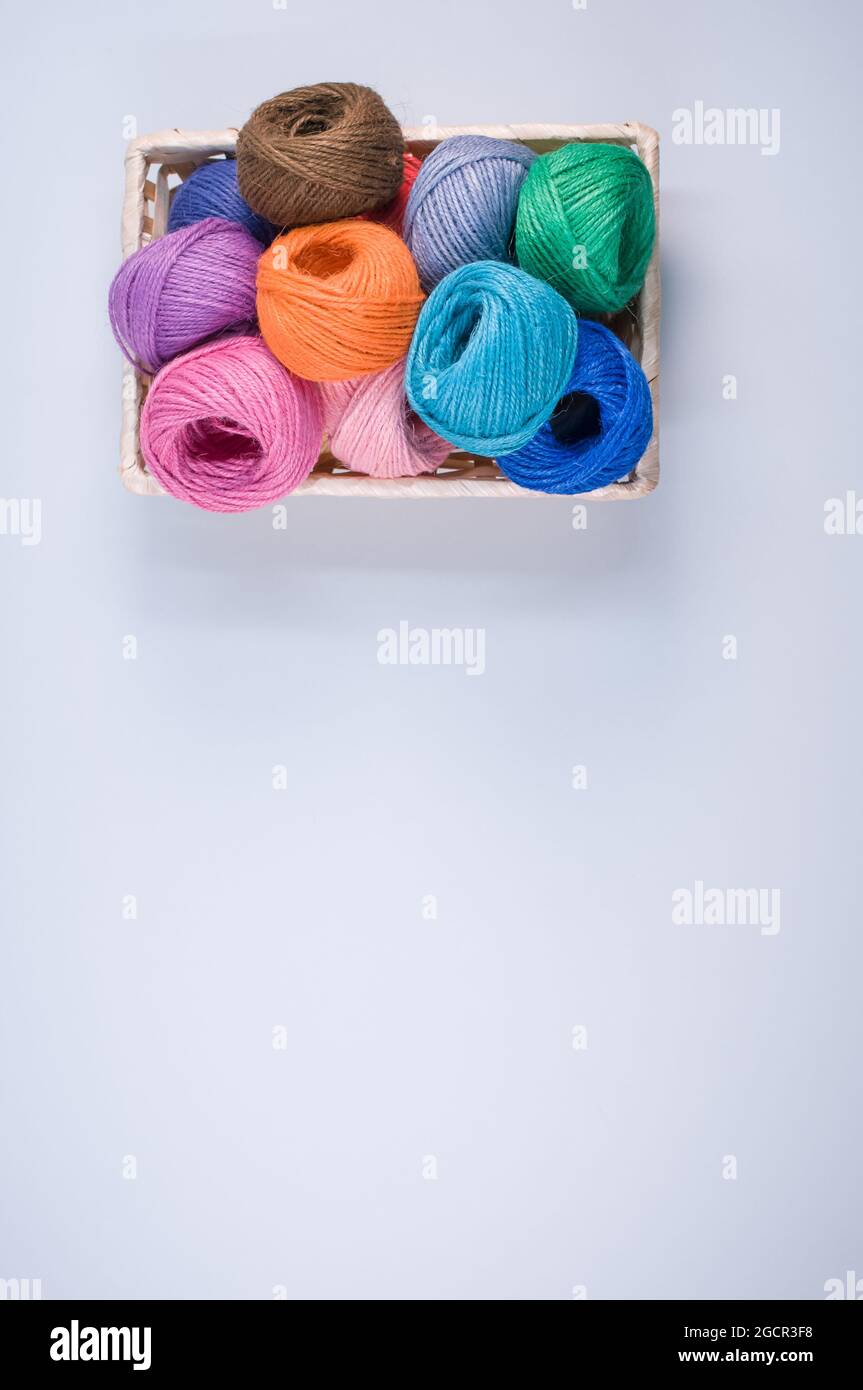 Basket full of colorful yarn rolls isolated on a white background with ...