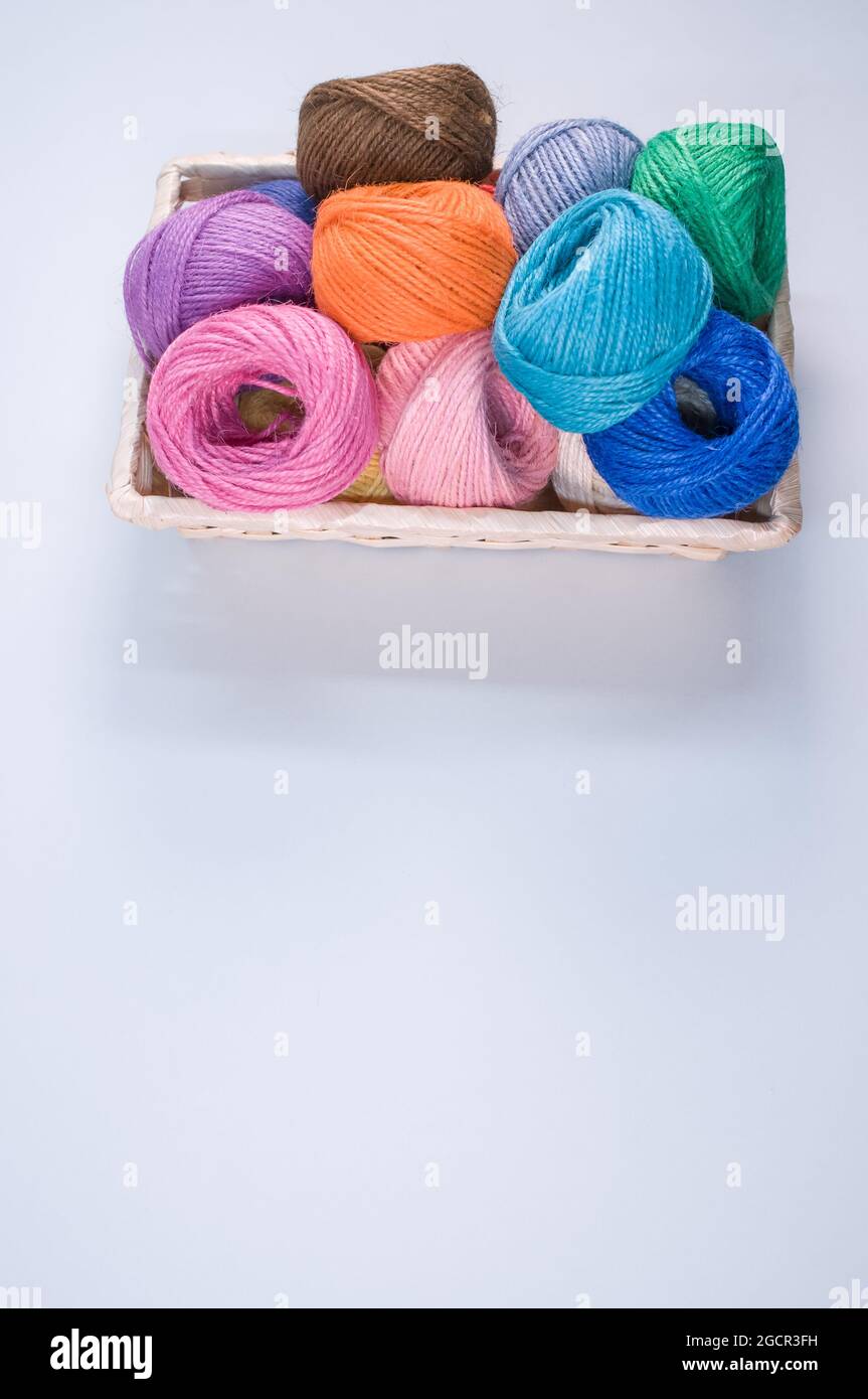 Basket full of colorful yarn rolls isolated on a white background with ...
