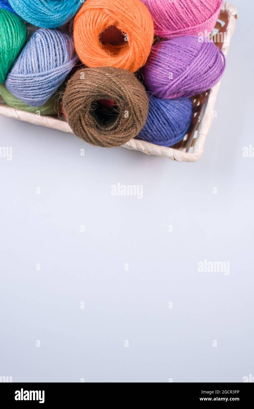 Basket full of colorful yarn rolls isolated on a white background with ...
