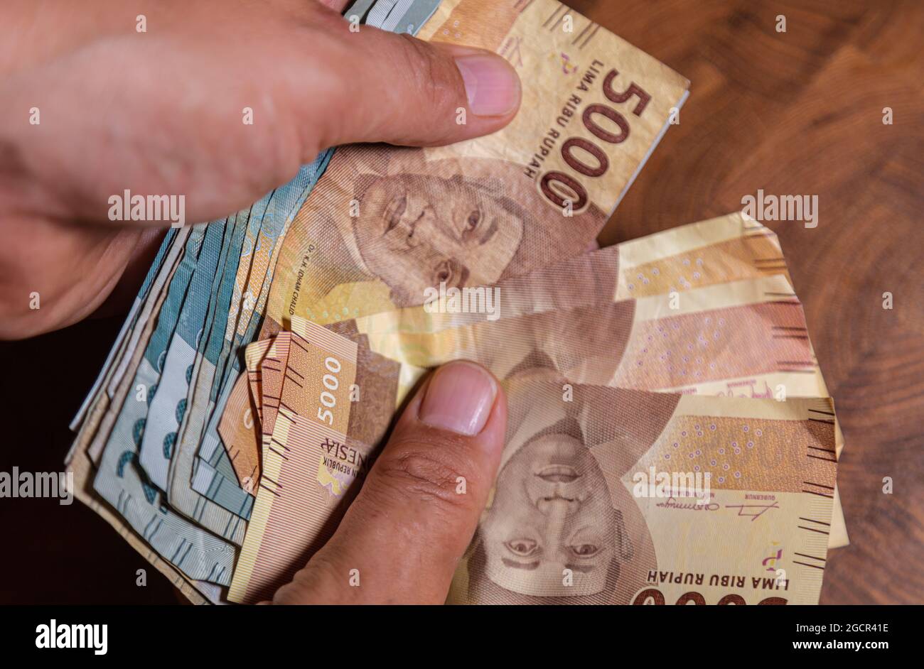 Male hand hold a fan Indonesia rupiah banknote, the currency of ...