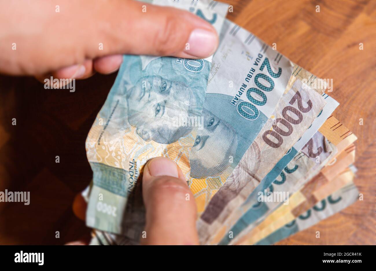 Male hand hold a fan Indonesia rupiah banknote, the currency of ...