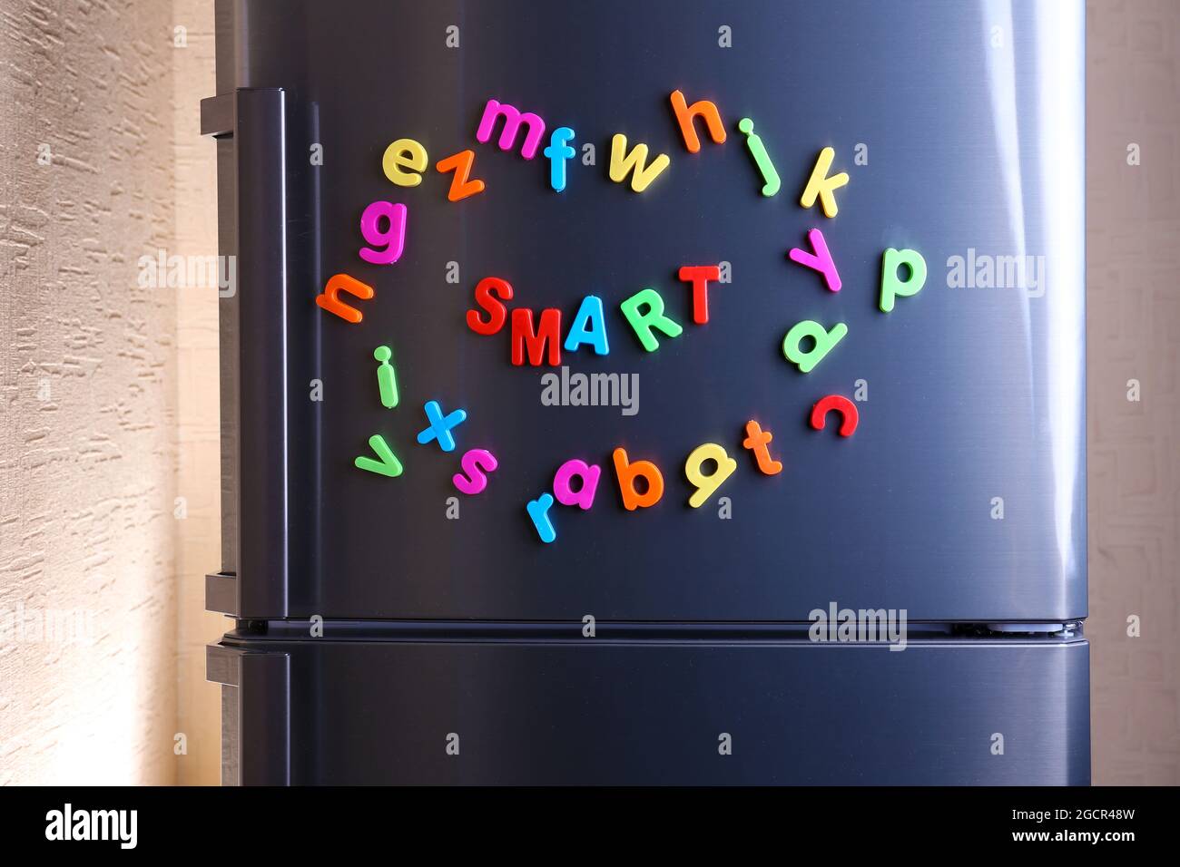 Word Smart spelled out using colorful magnetic letters on refrigerator ...