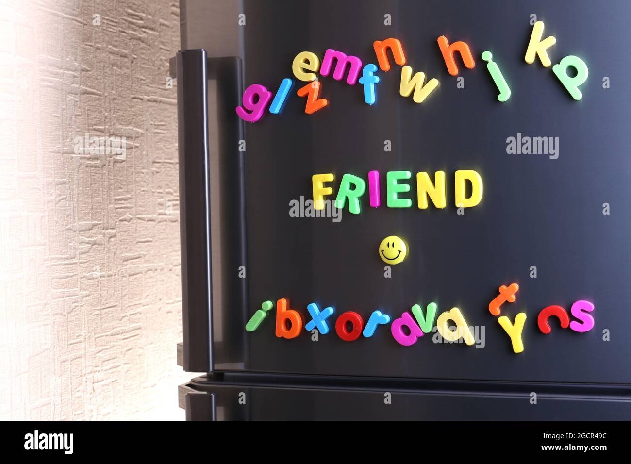 Word Friend spelled out using colorful magnetic letters on refrigerator ...