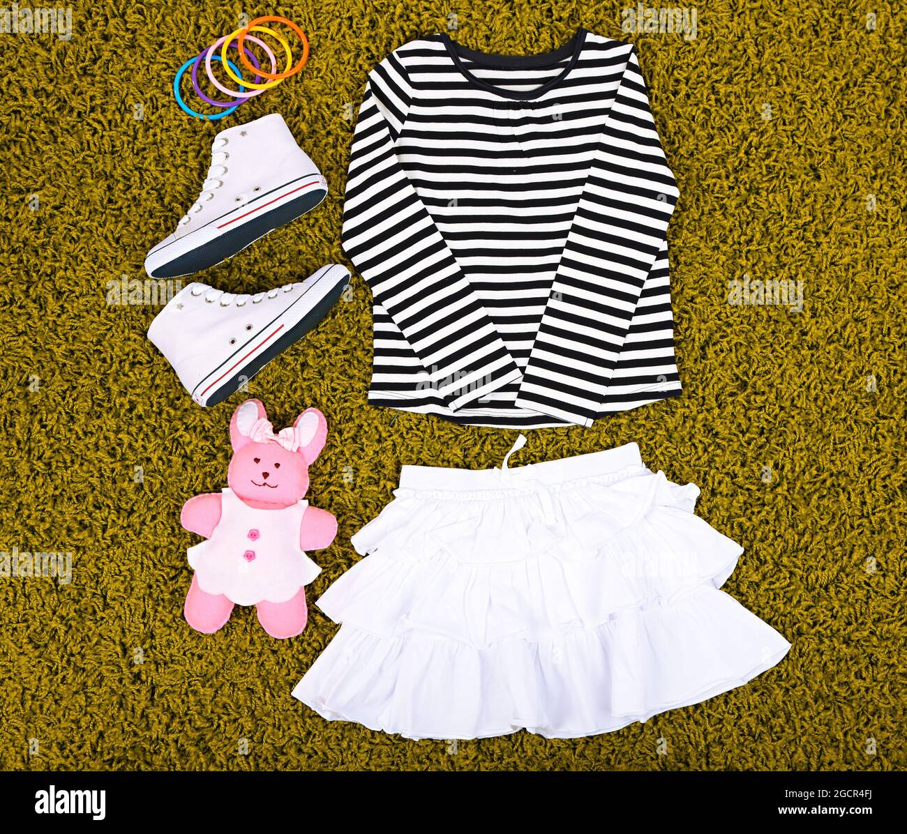 Beautiful clothes for little girl on green carpet Stock Photo - Alamy