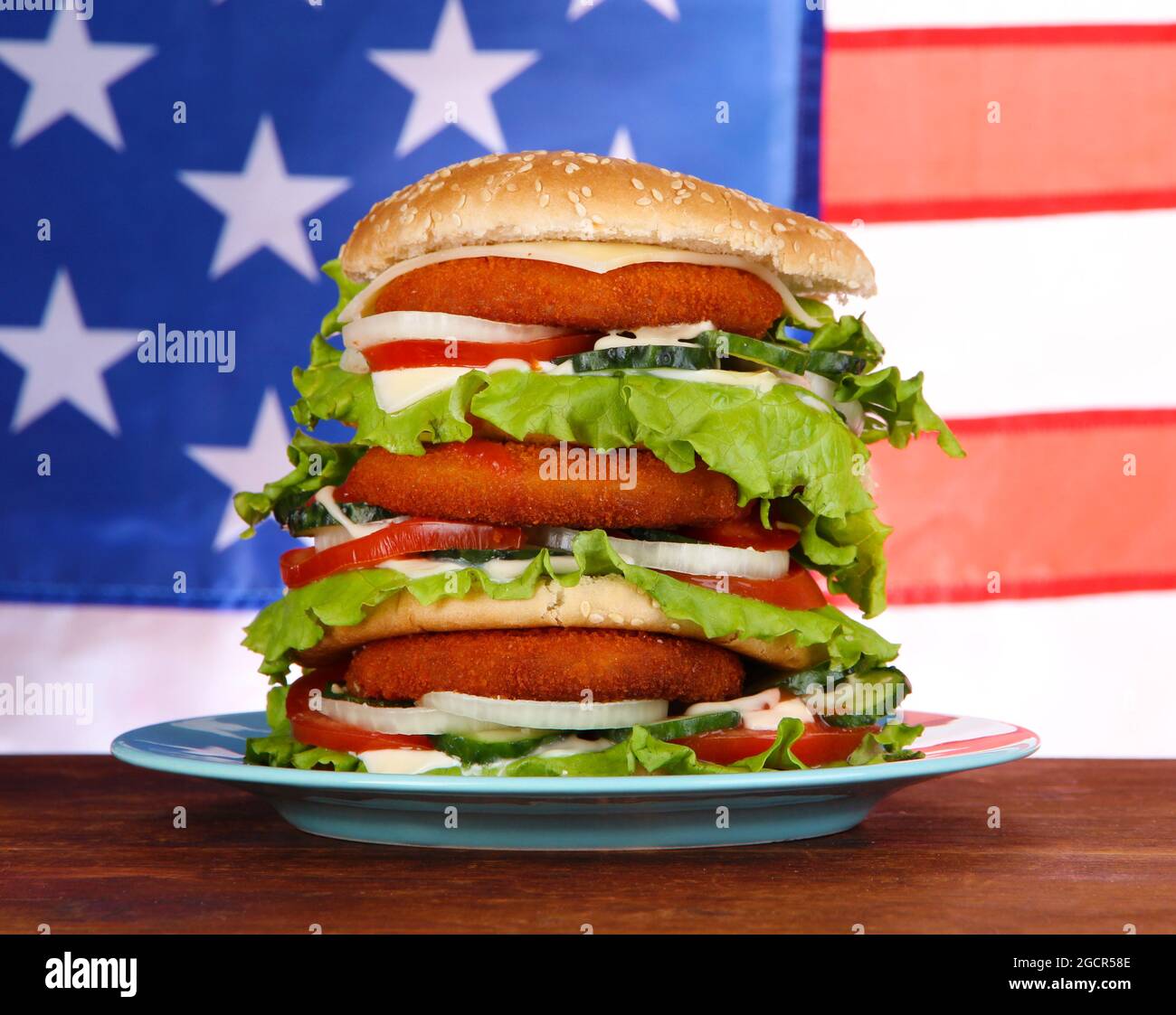 Huge burger on color plate on USA flag background Stock Photo - Alamy