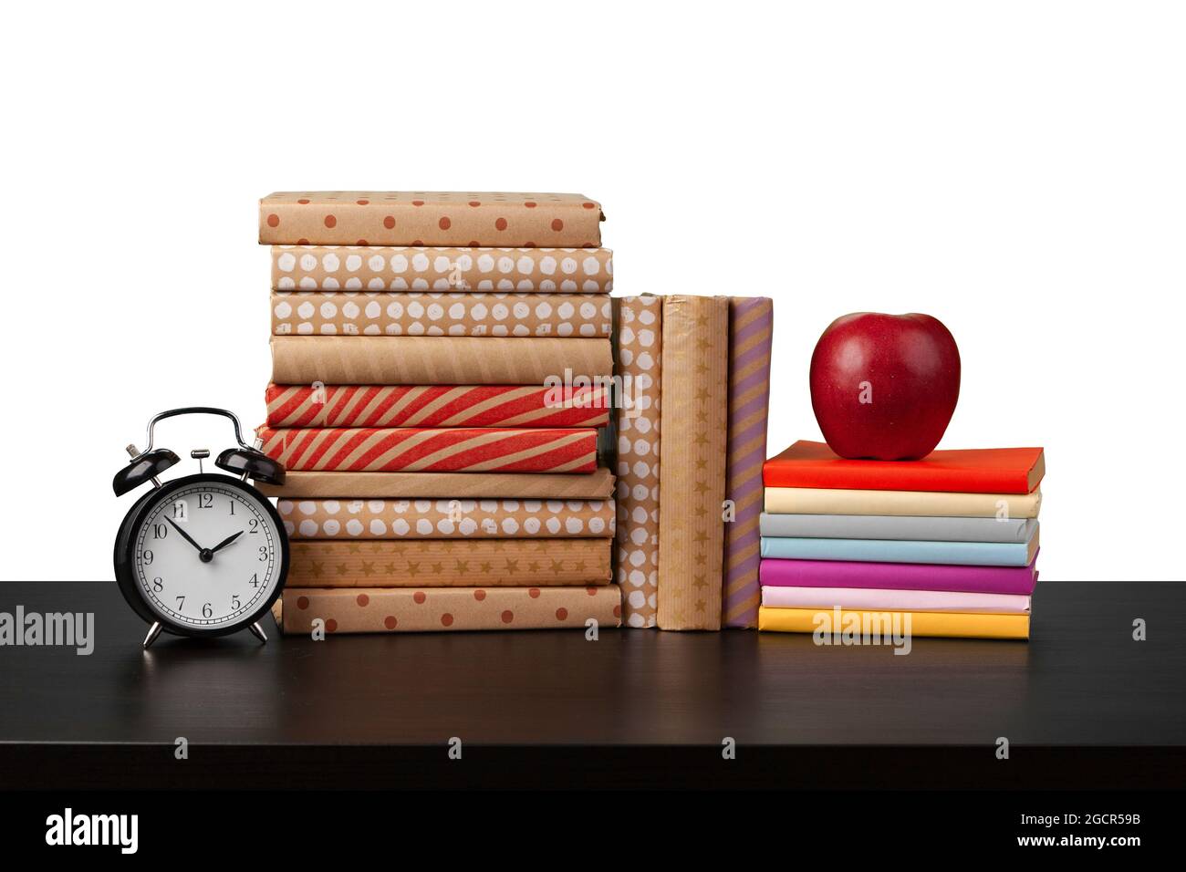 Stack of books and apple on tabletop against white background Stock ...
