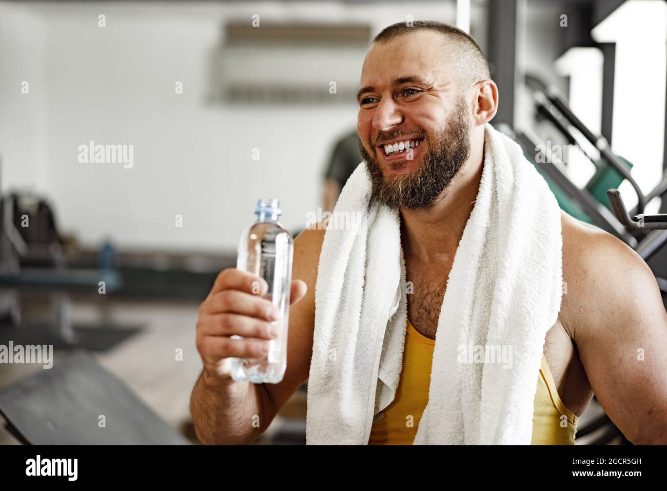 Cheerful smiling man bodybuilder standing in a gym Stock Photo - Alamy