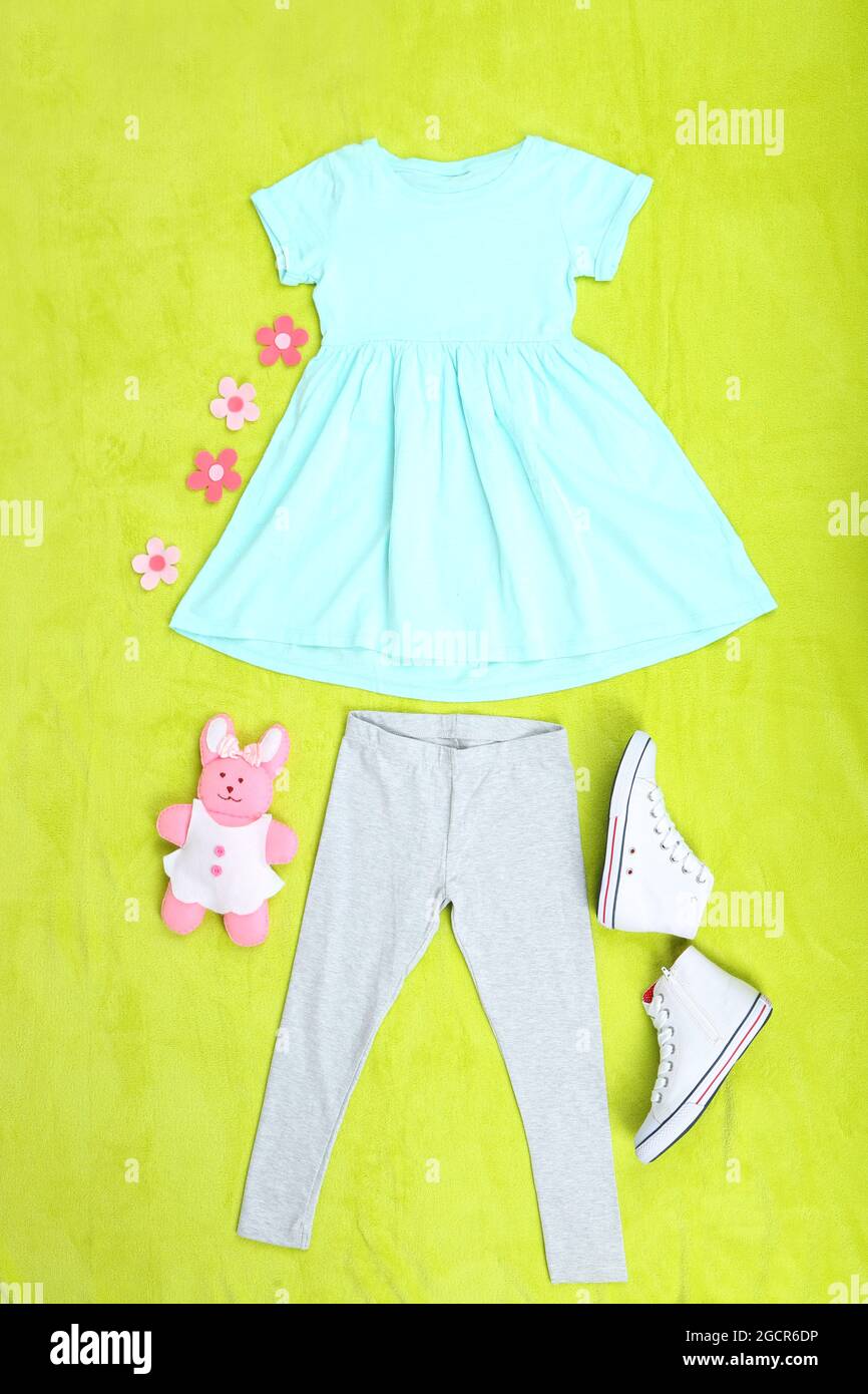 Beautiful clothes for little girl on green background Stock Photo - Alamy