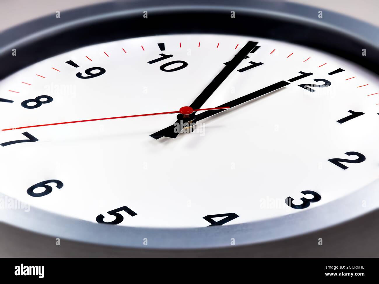 It's five to twelve, the clock is ticking. Modern wall clock shows the ...