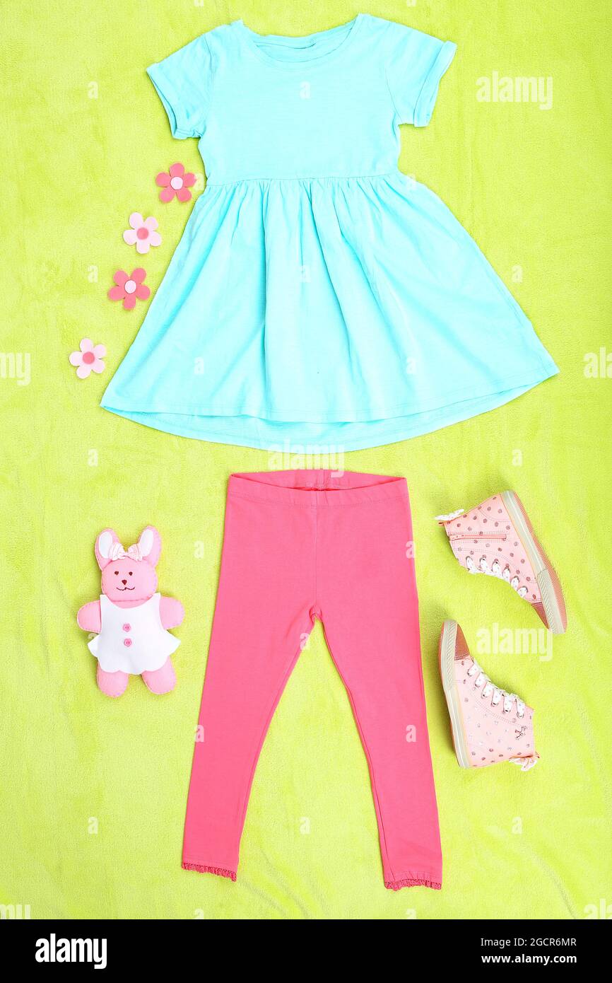 Beautiful clothes for little girl on green background Stock Photo - Alamy
