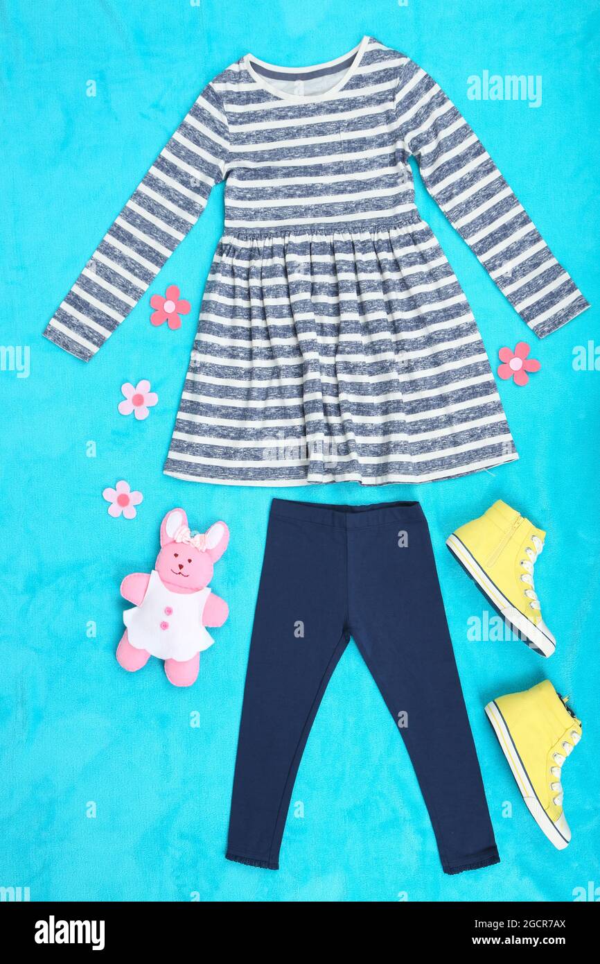 Beautiful clothes for little girl on blue background Stock Photo - Alamy