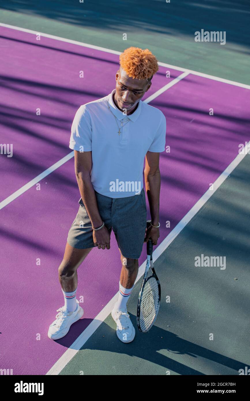 Handsome young man on tennis court Stock Photo - Alamy