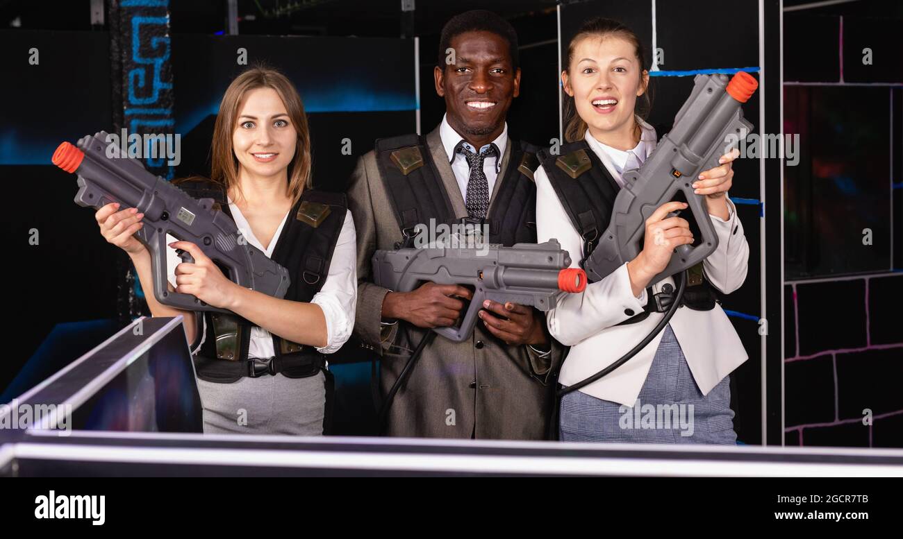 Smiling associates - afro man and two European women posing at laser ...