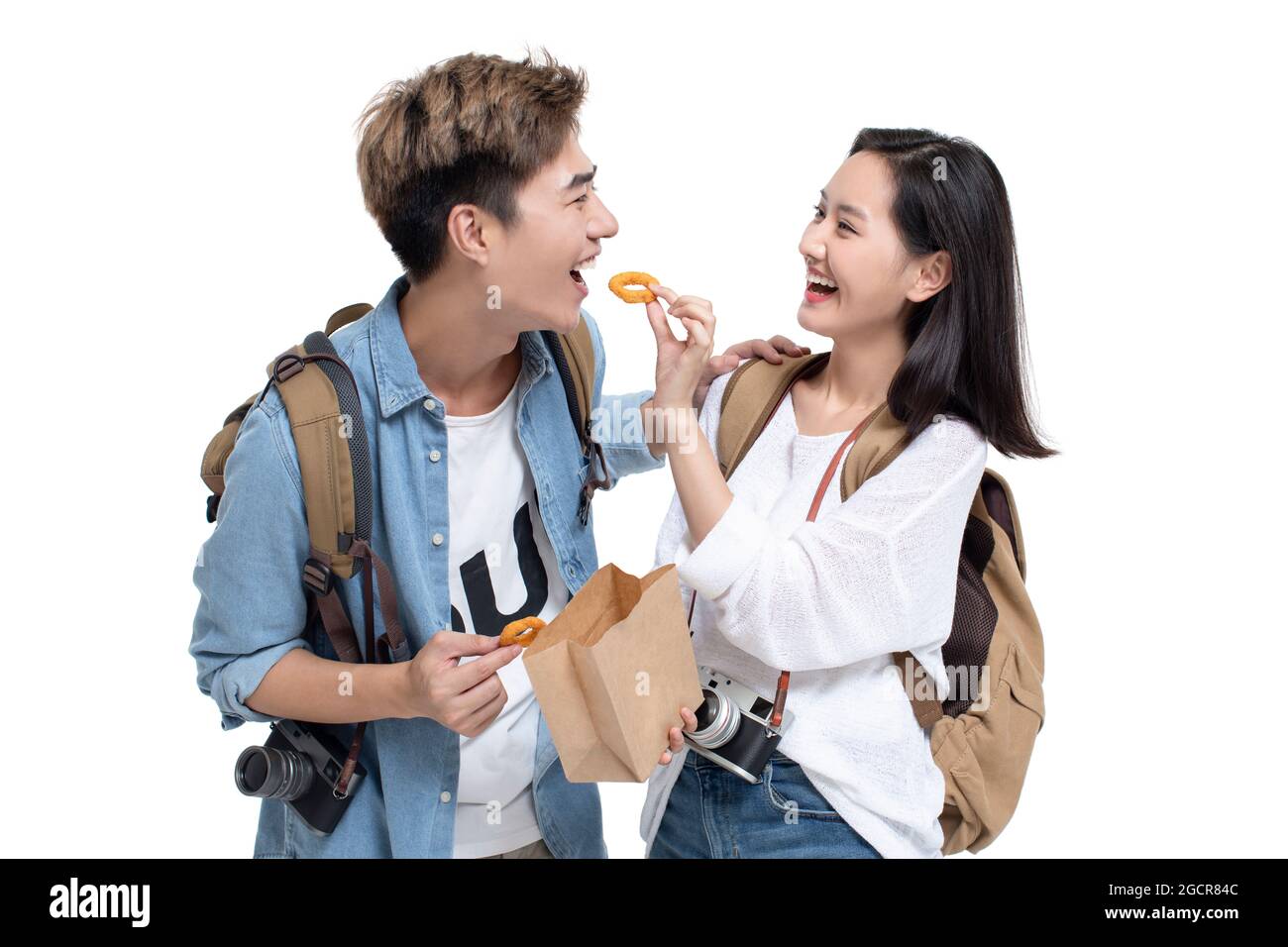 Happy young couple sharing snack Stock Photo - Alamy