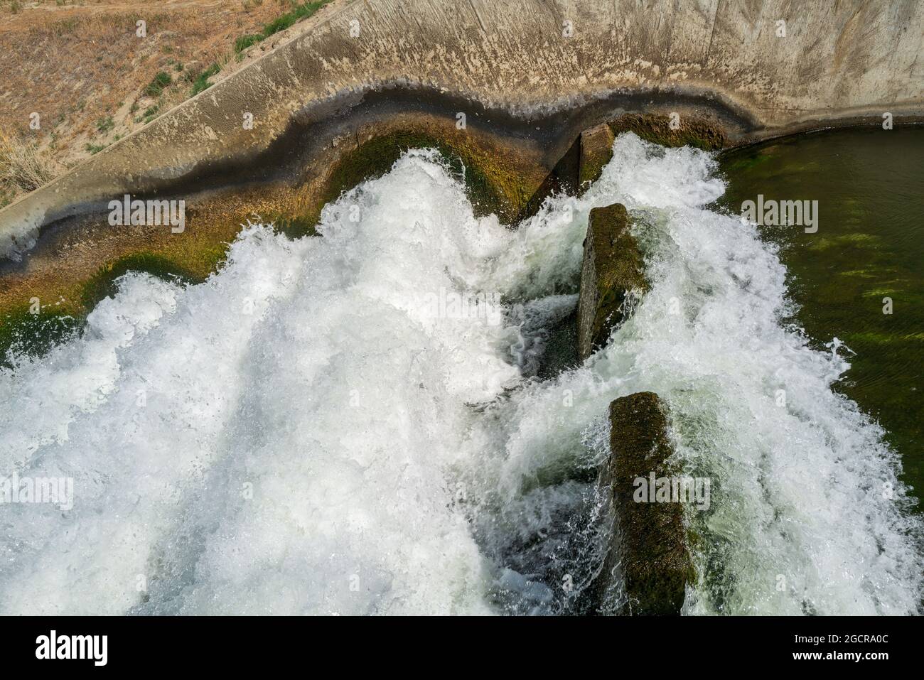 Water flows down a concrete channel from the Ringold Pond Dam toward ...