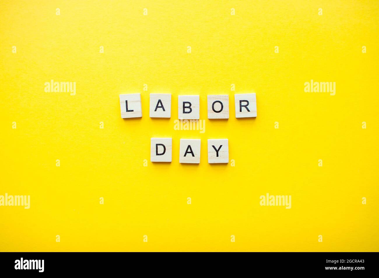 The inscription labor day from wooden blocks on a bright yellow ...