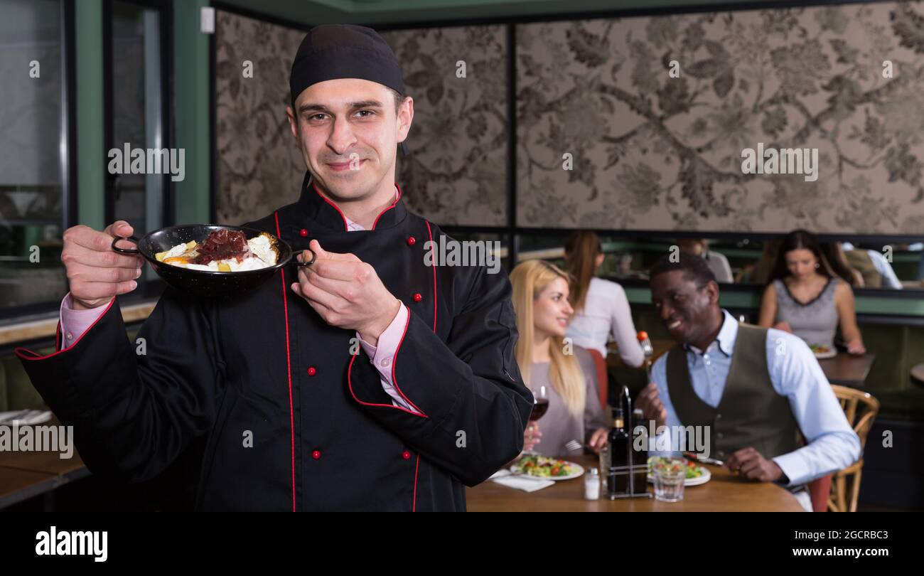 Confident chef with dish in restaurant hall Stock Photo - Alamy