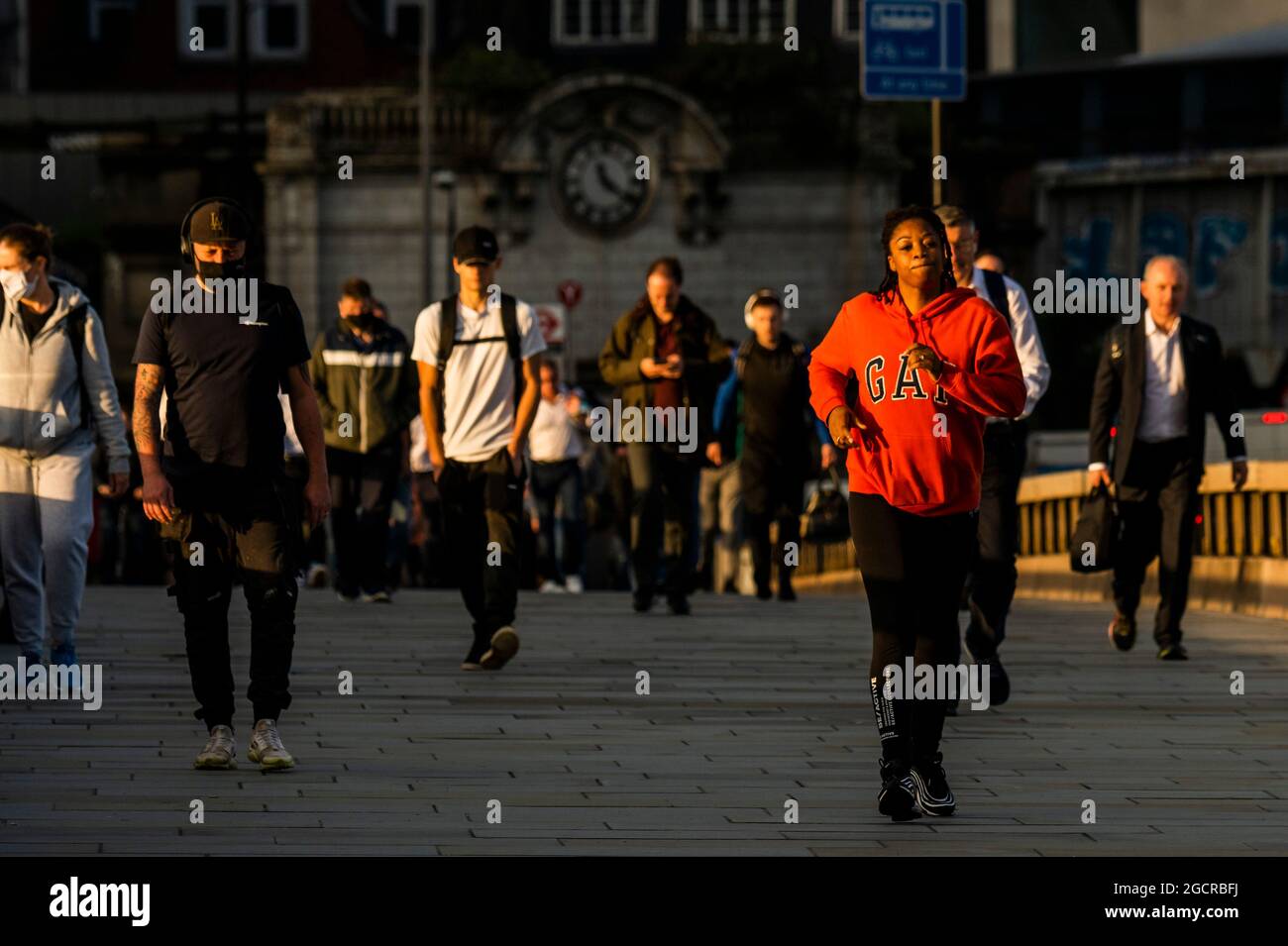 London, UK. 10th Aug, 2021. Early commuters walk over the bridge - The ...