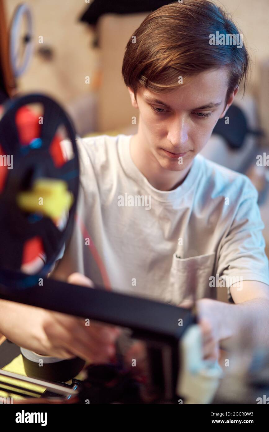 Young man set up 3d printer at home Stock Photo - Alamy