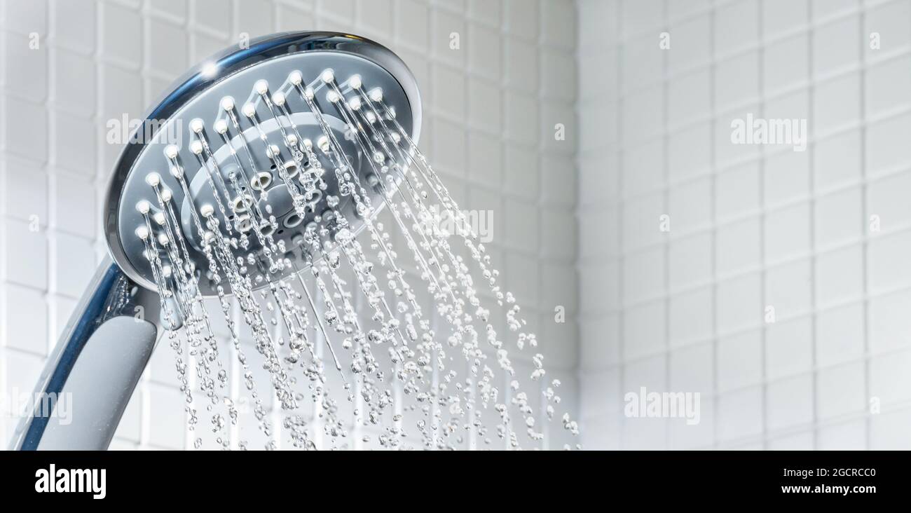 Modern Shower head with running water in white bathroom Stock Photo - Alamy