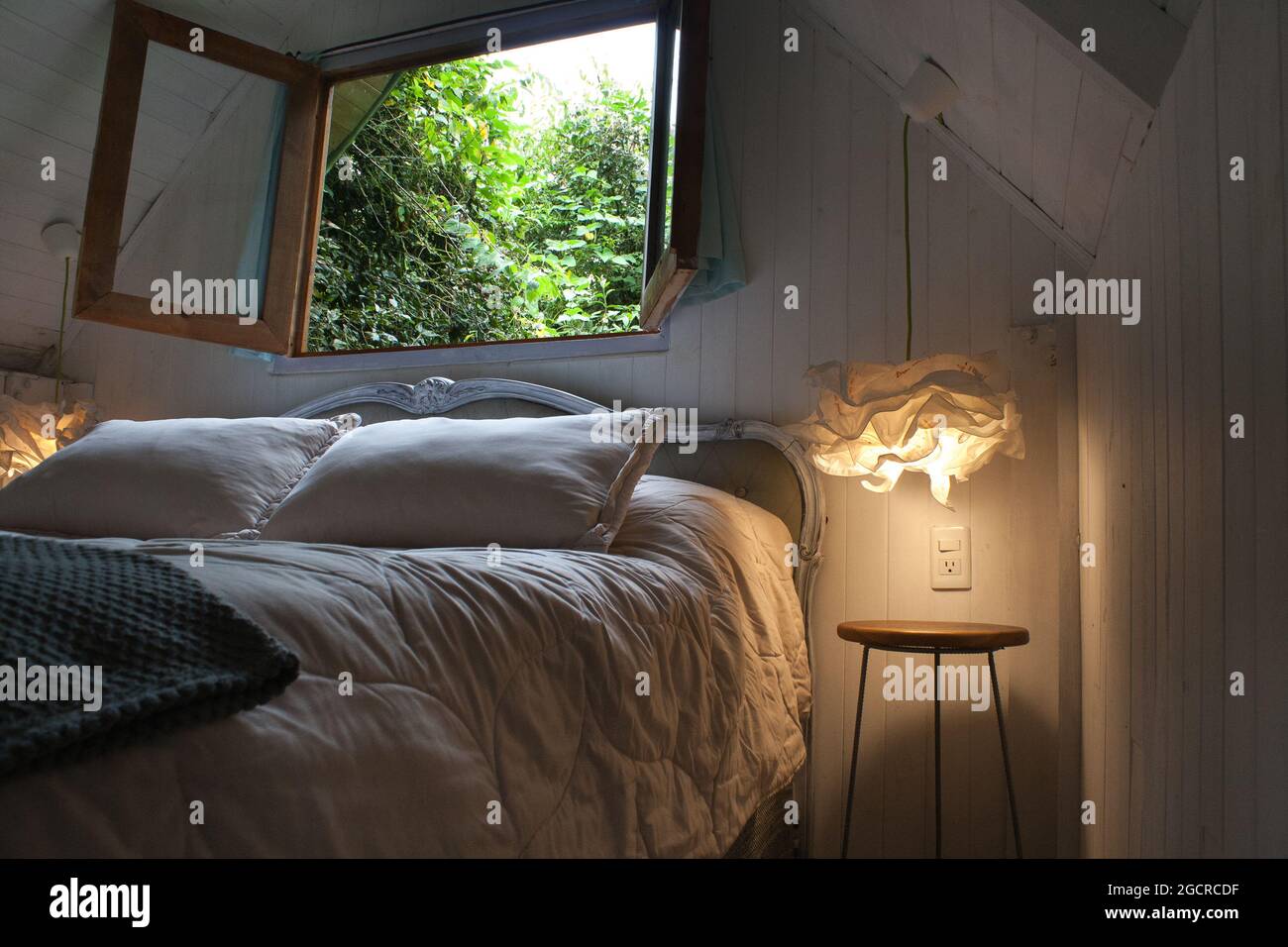 Cozy bedroom with open windows with a view of a forest Stock Photo - Alamy