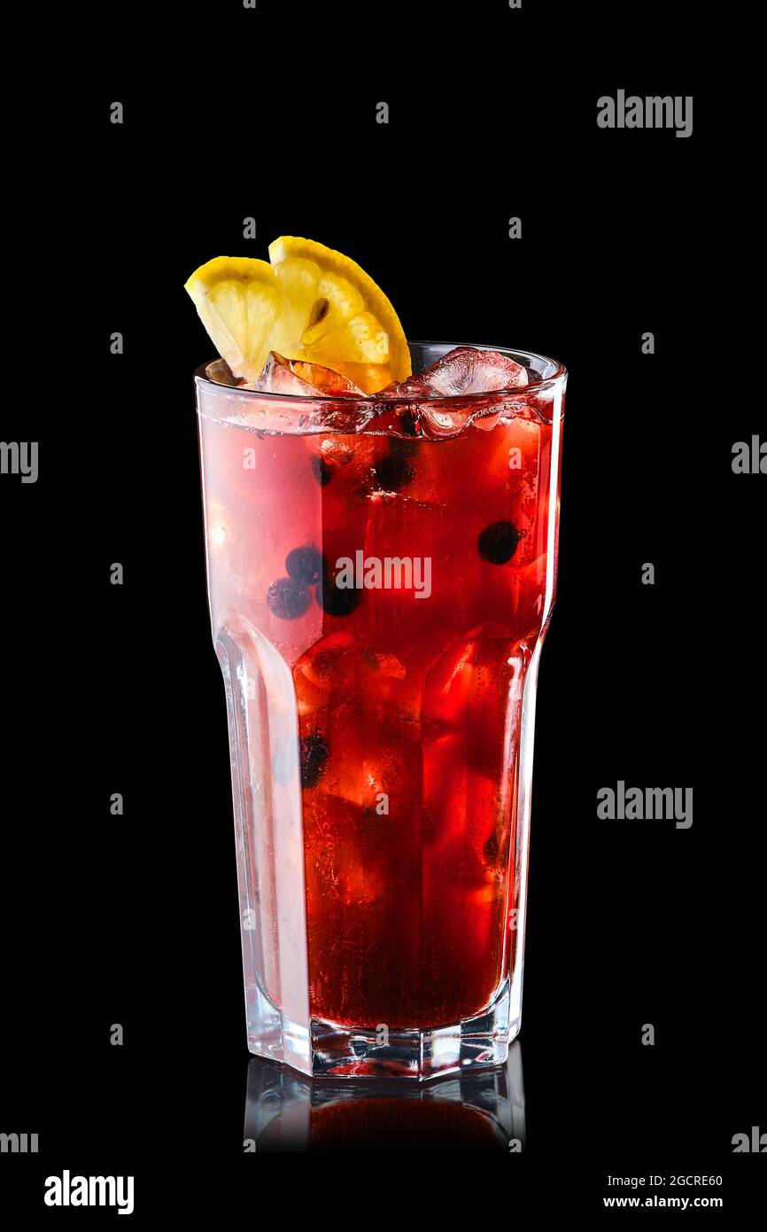 Cold lemonade with orange juice and black currant isolated on black ...