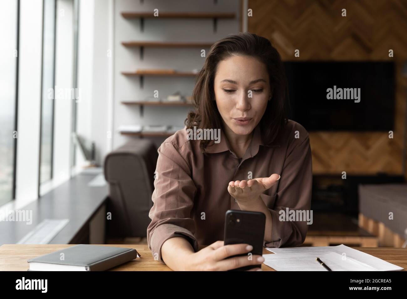 Happy young business woman making personal video call from workplace ...