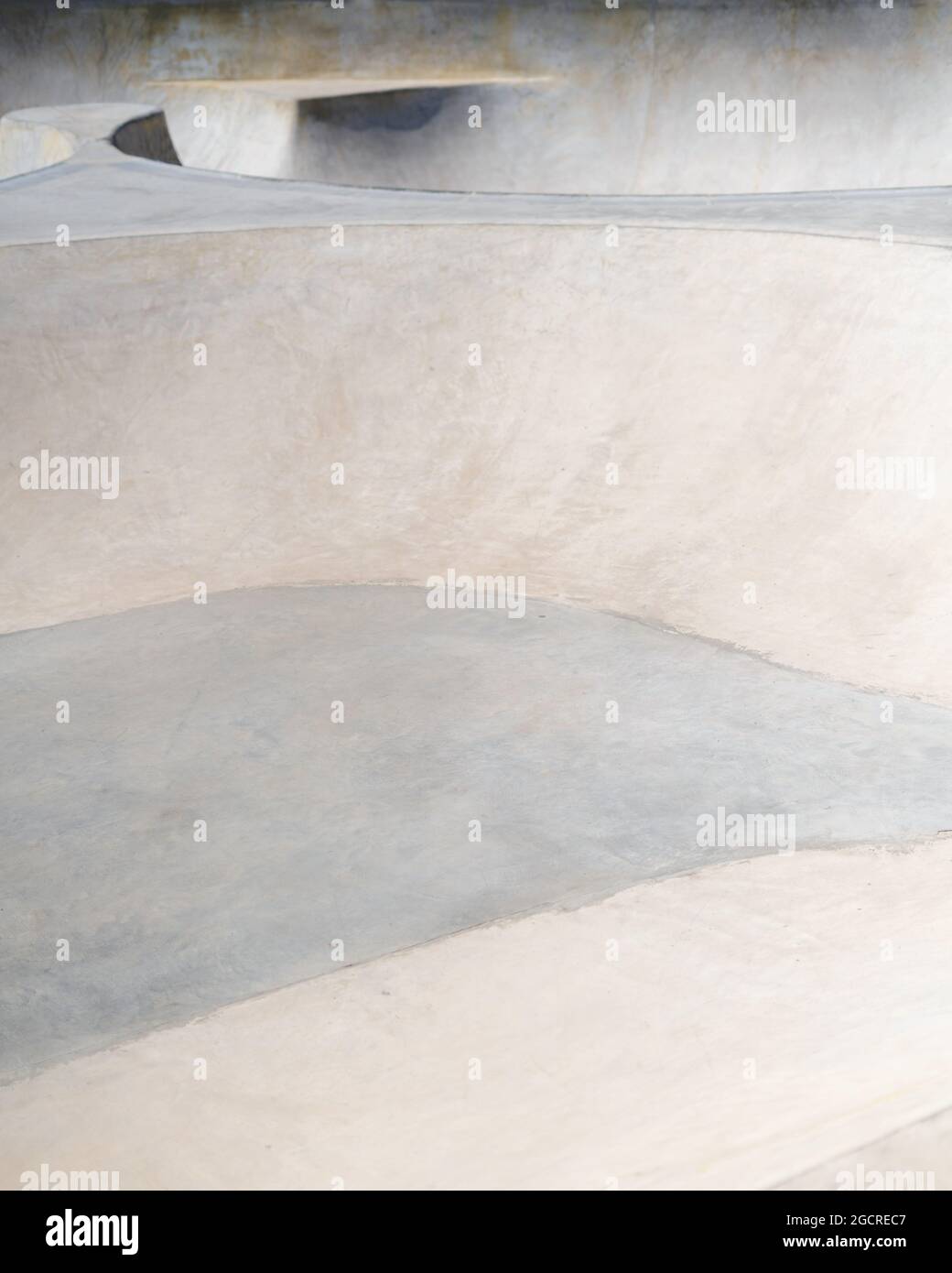 Concrete public skate park on a sunny day. Cement ramps for ...