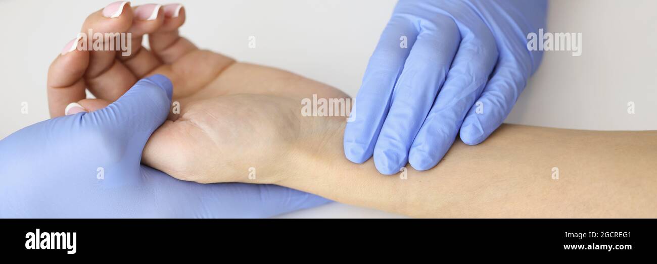Doctor measuring pulse on patient forearm near empty syringe and ...
