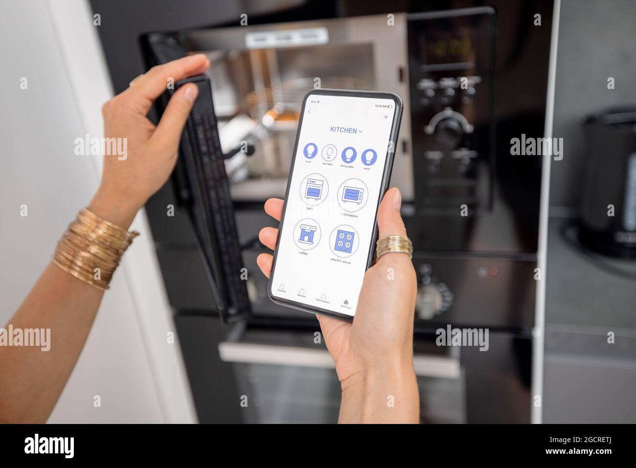 Controlling smart devices with phone on the kitchen Stock Photo - Alamy